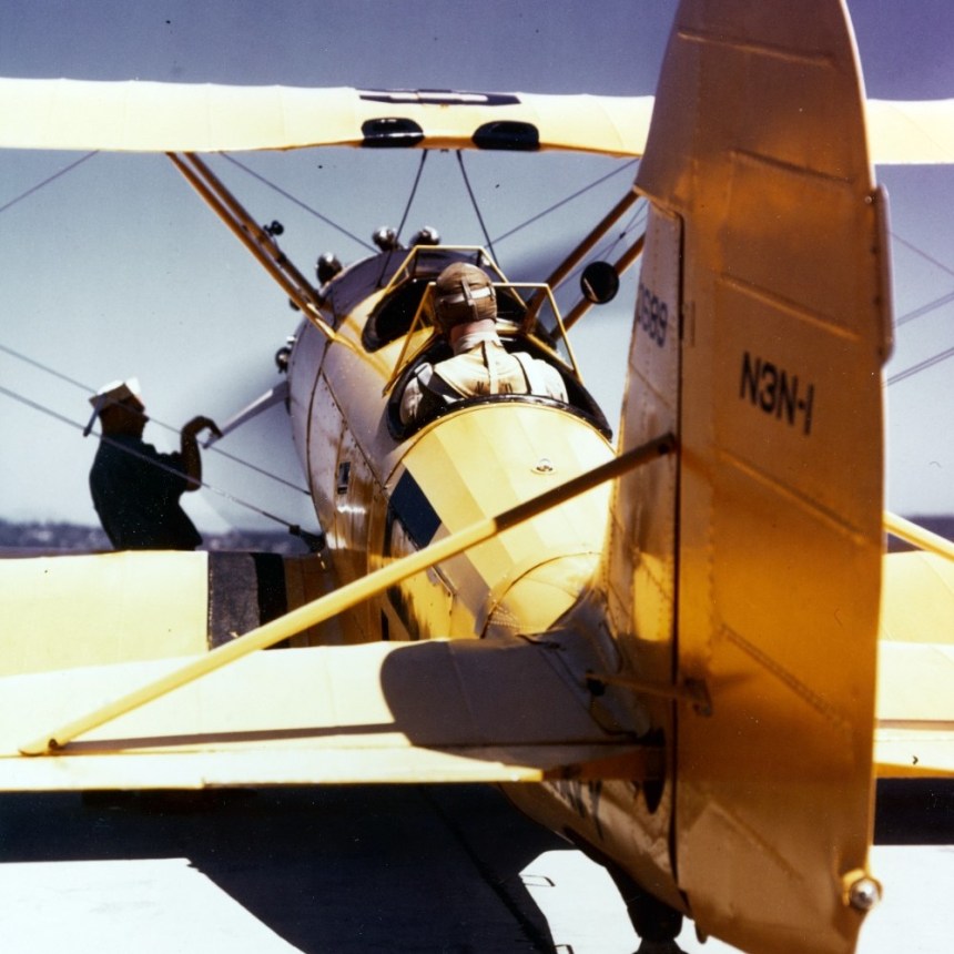 Yellow peril Sailor cranks the engine of an N3N training flight, circa ...